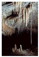 Stalactites hang from the cave ceiling like dripping icicles. One ...
